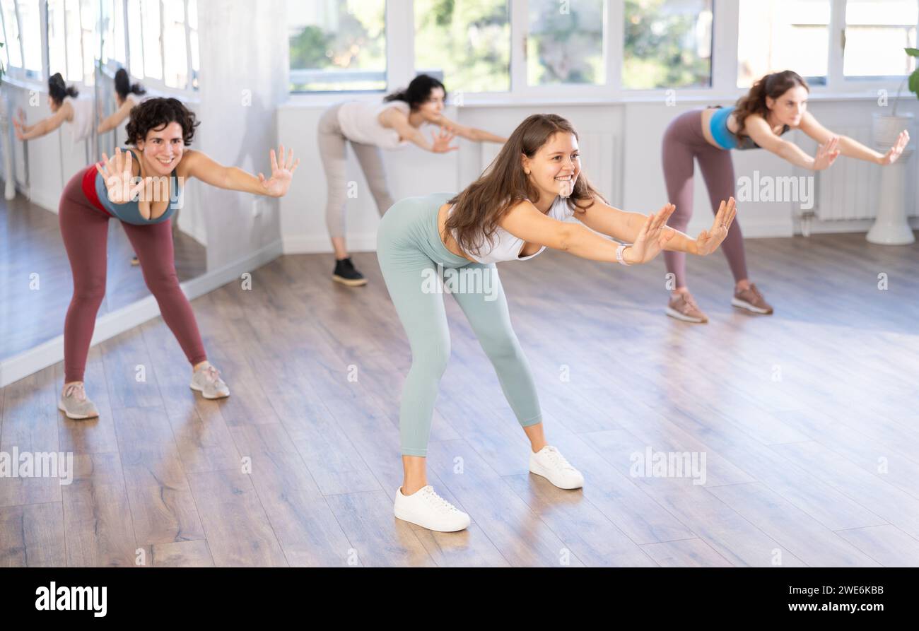 Young female teacher conducts modern dance lessons for group of girls ...