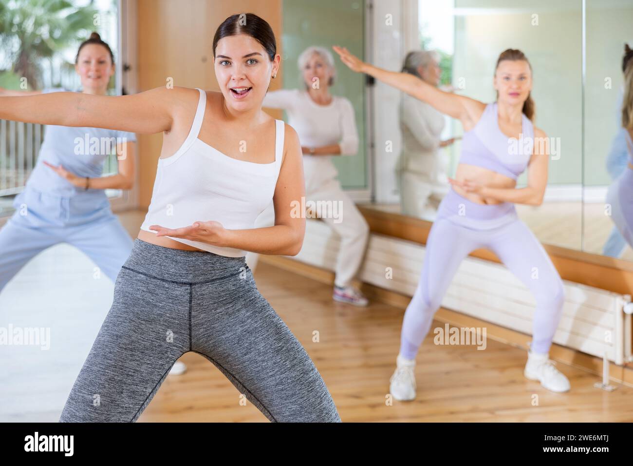 Group of active women of different ages learning new dynamic exercise ...
