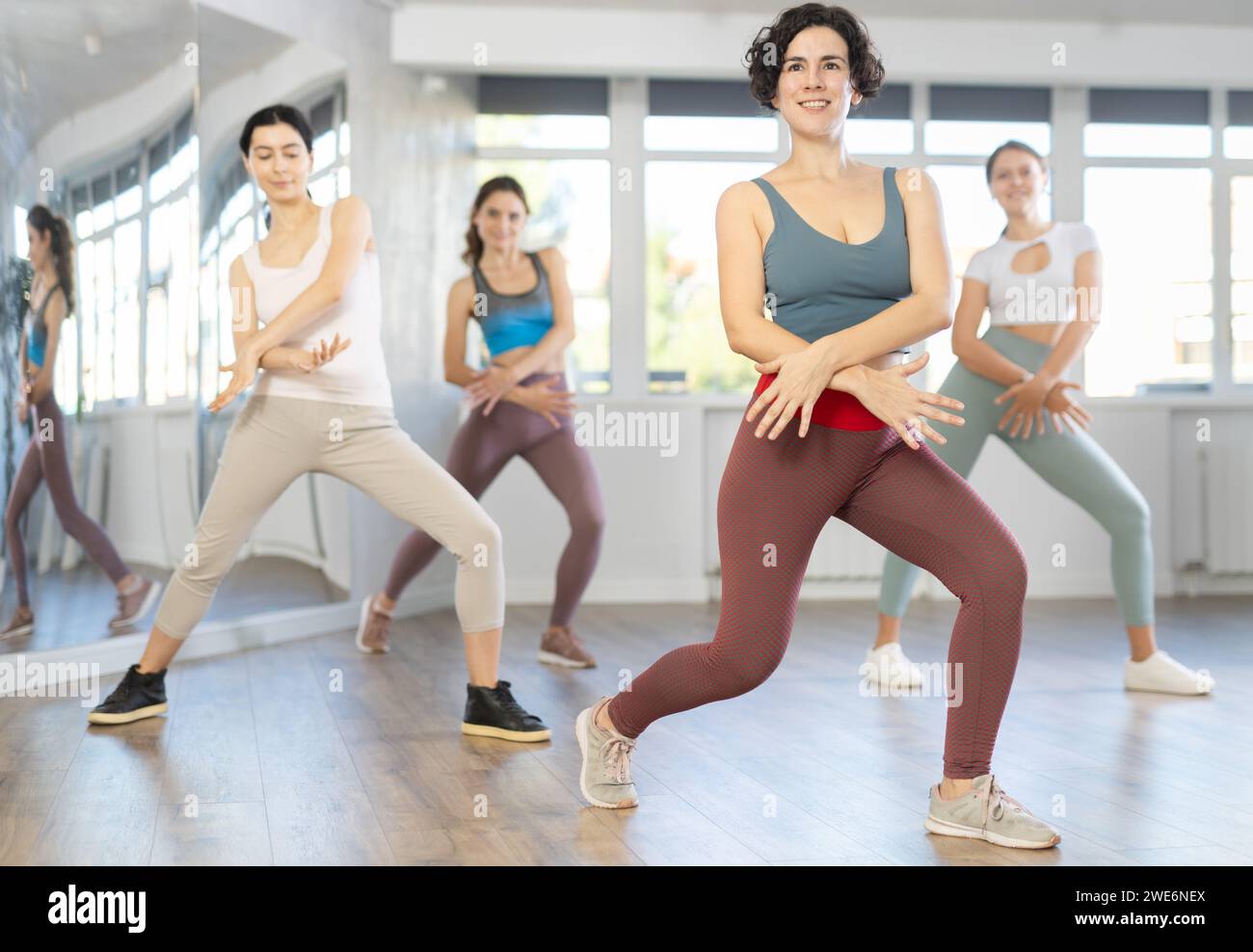 Happy women dancing synchronous group choreography in dance hall Stock ...