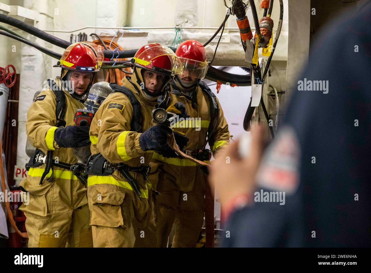 Sailors fight a simulated fire during a damage control training team ...