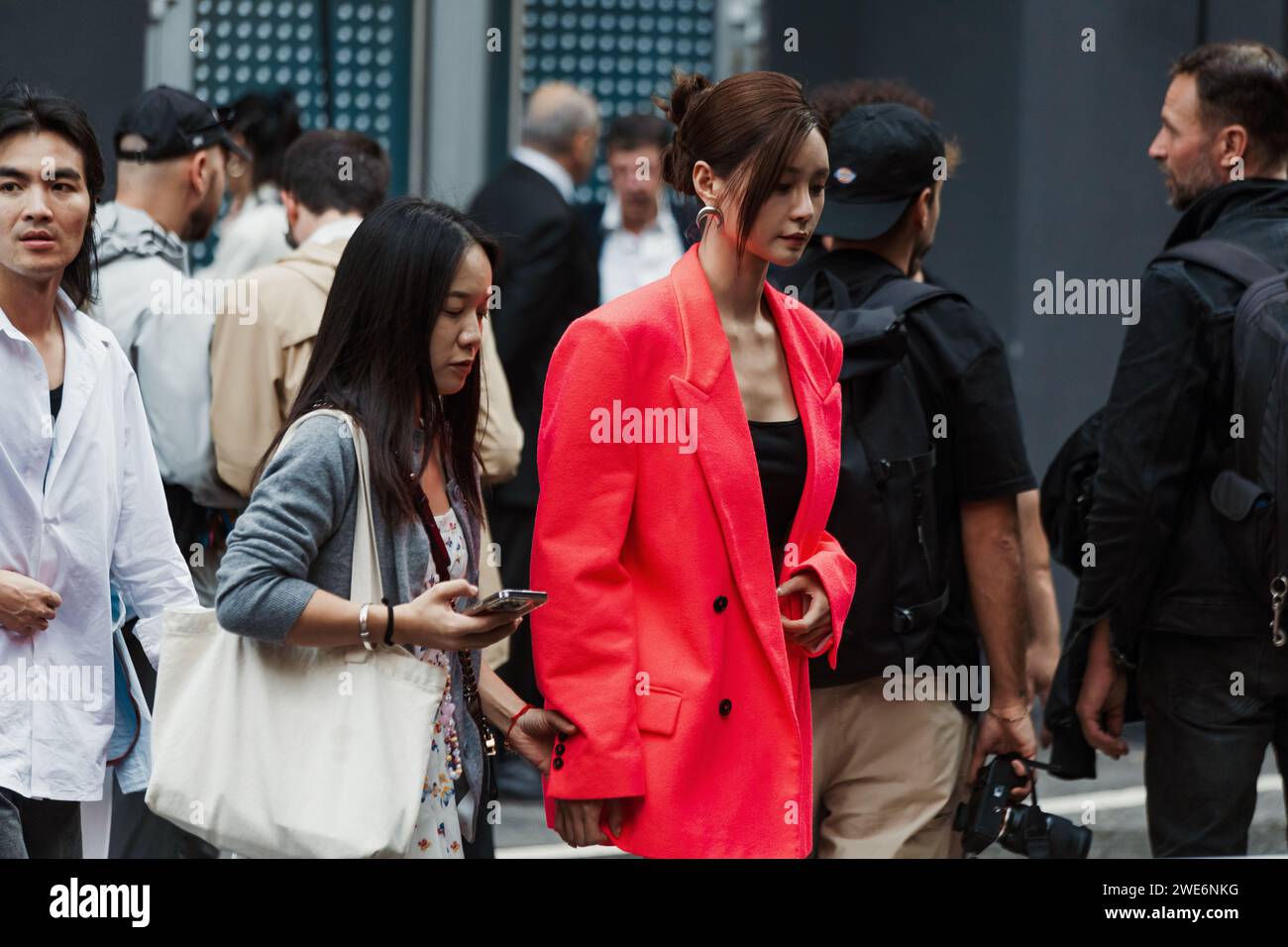 A guest wears a pink neon blazer and miniskirt, outside MSGM show ...