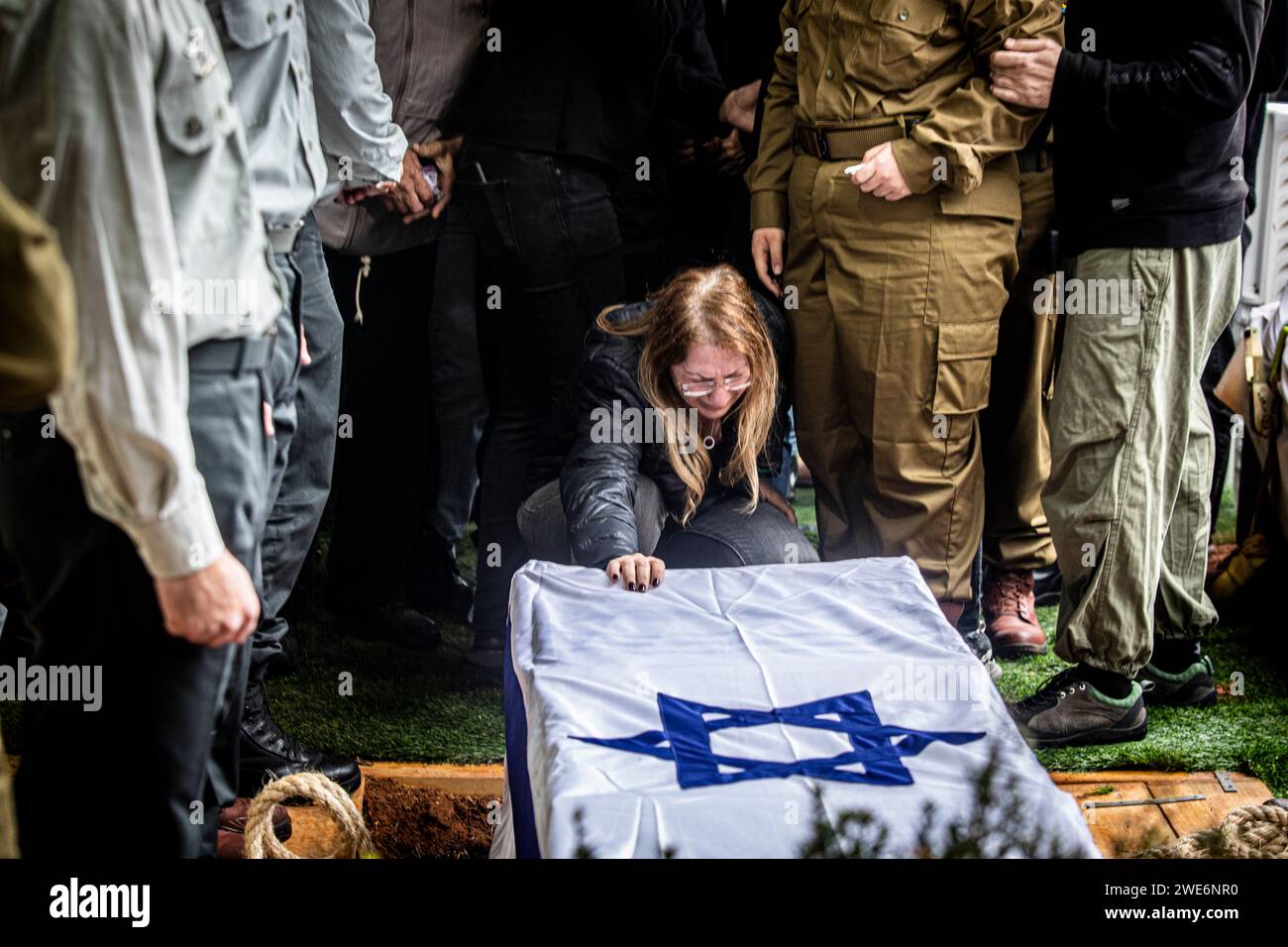 A family member weeps as she touches the coffin of Major Ilay Levy ...