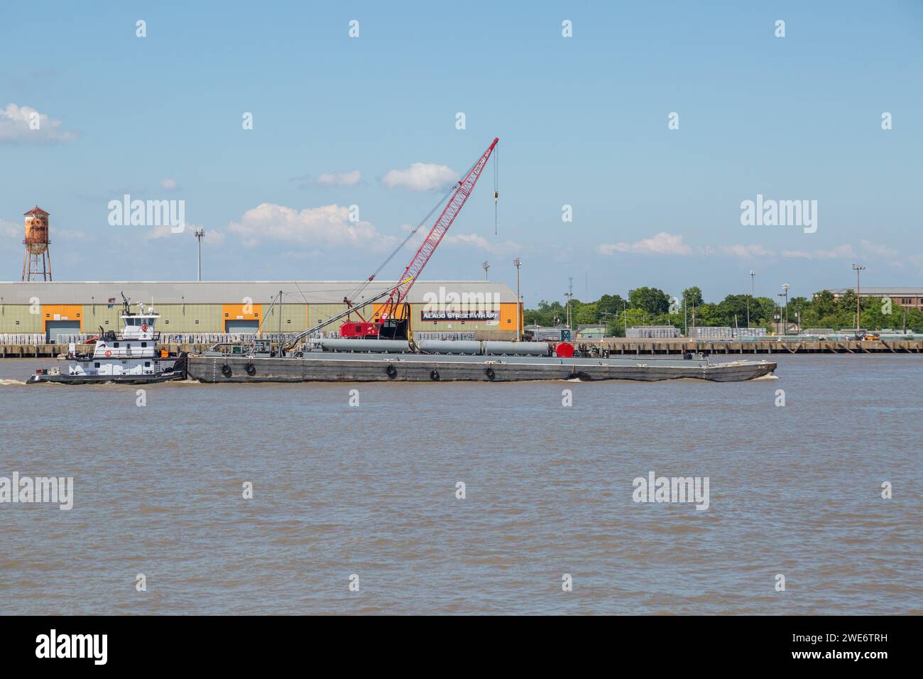 Tug boat Jennifer pushing a large barge with construction equipment up ...