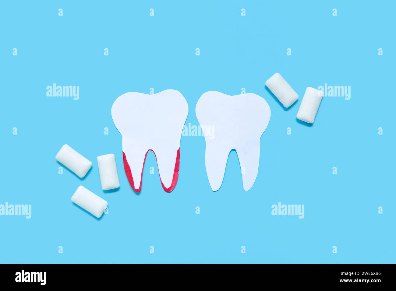 Paper teeth and white chewing gums on blue background Stock Photo - Alamy