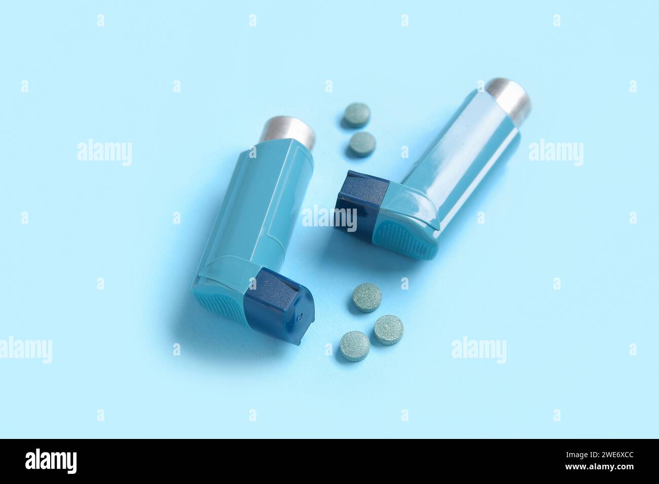 Asthma inhalers with pills on blue background Stock Photo - Alamy