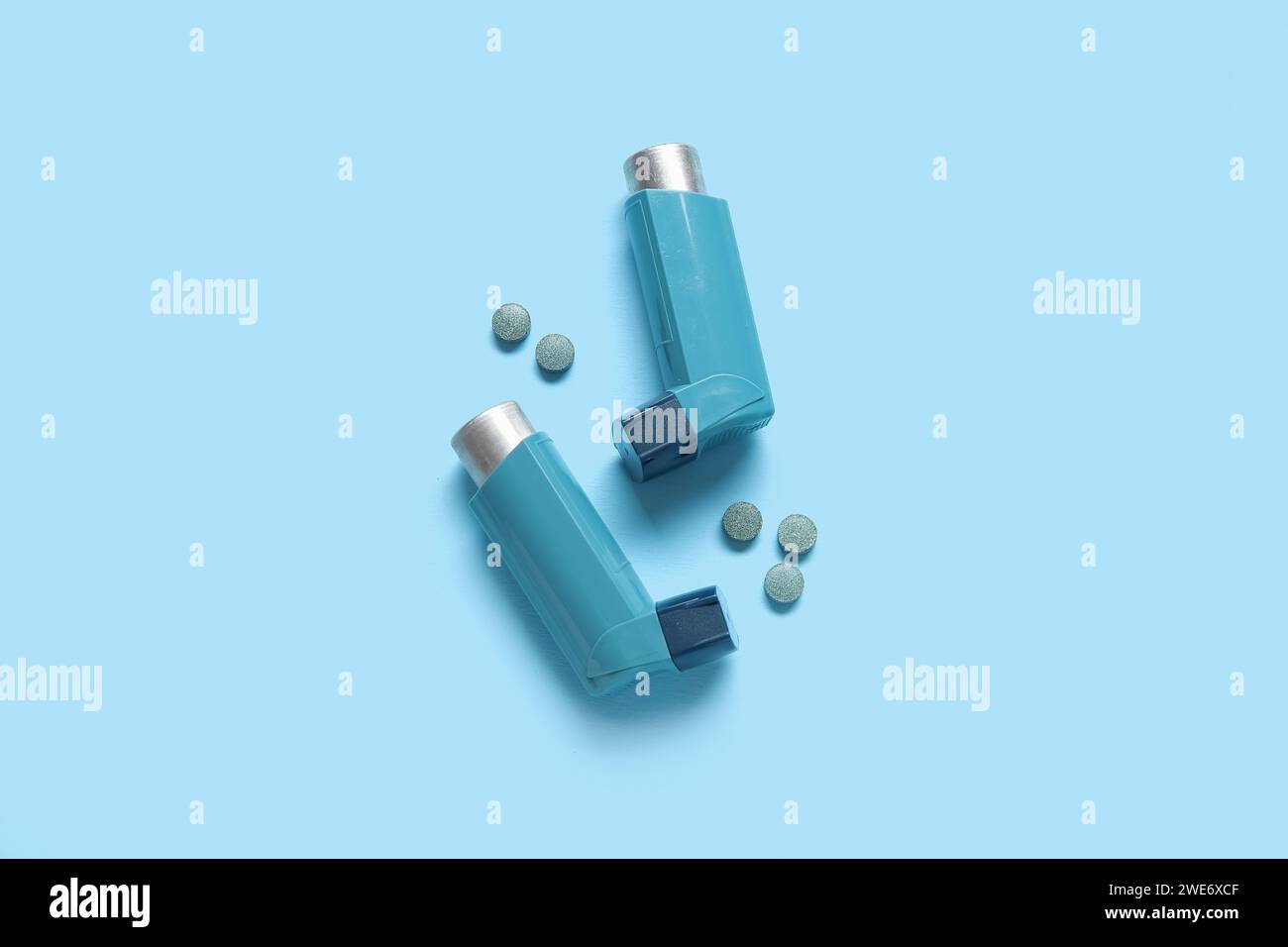Asthma inhalers with pills on blue background Stock Photo - Alamy