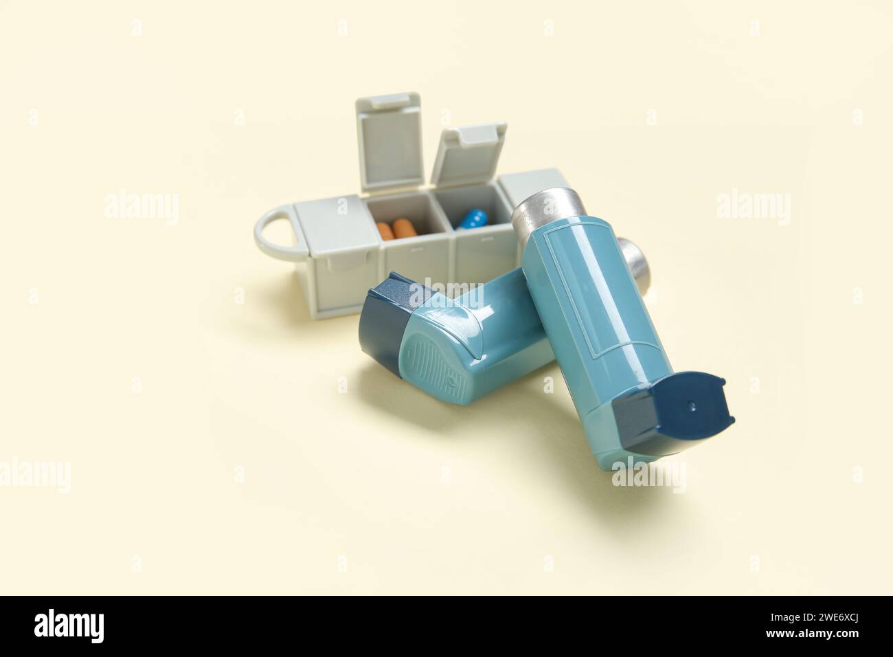 Asthma inhalers with pills case on yellow background Stock Photo - Alamy