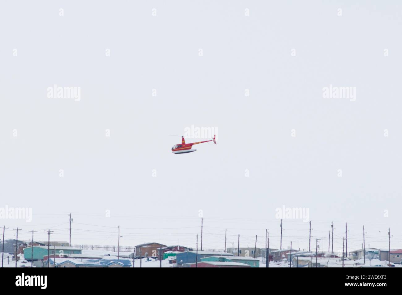 polar bear reaserch helicopter flying in air over Barter island village ...