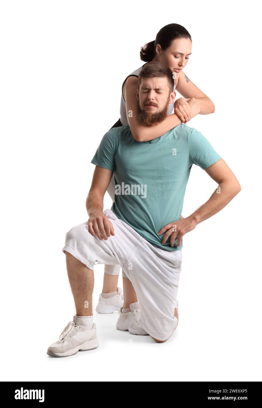 Young woman fighting with instructor of self-defence course on white ...