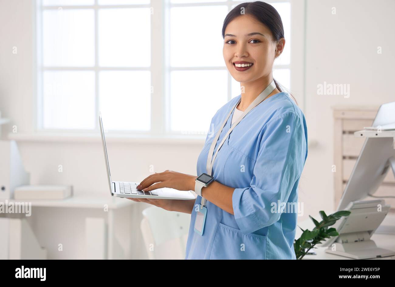 Female Asian medical intern using laptop in clinic Stock Photo - Alamy