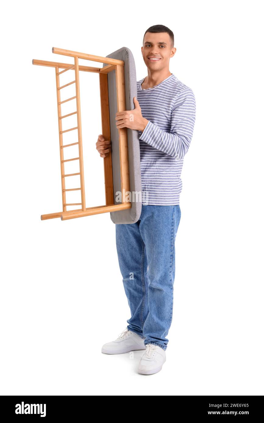 Young man carrying soft bench on white background Stock Photo - Alamy