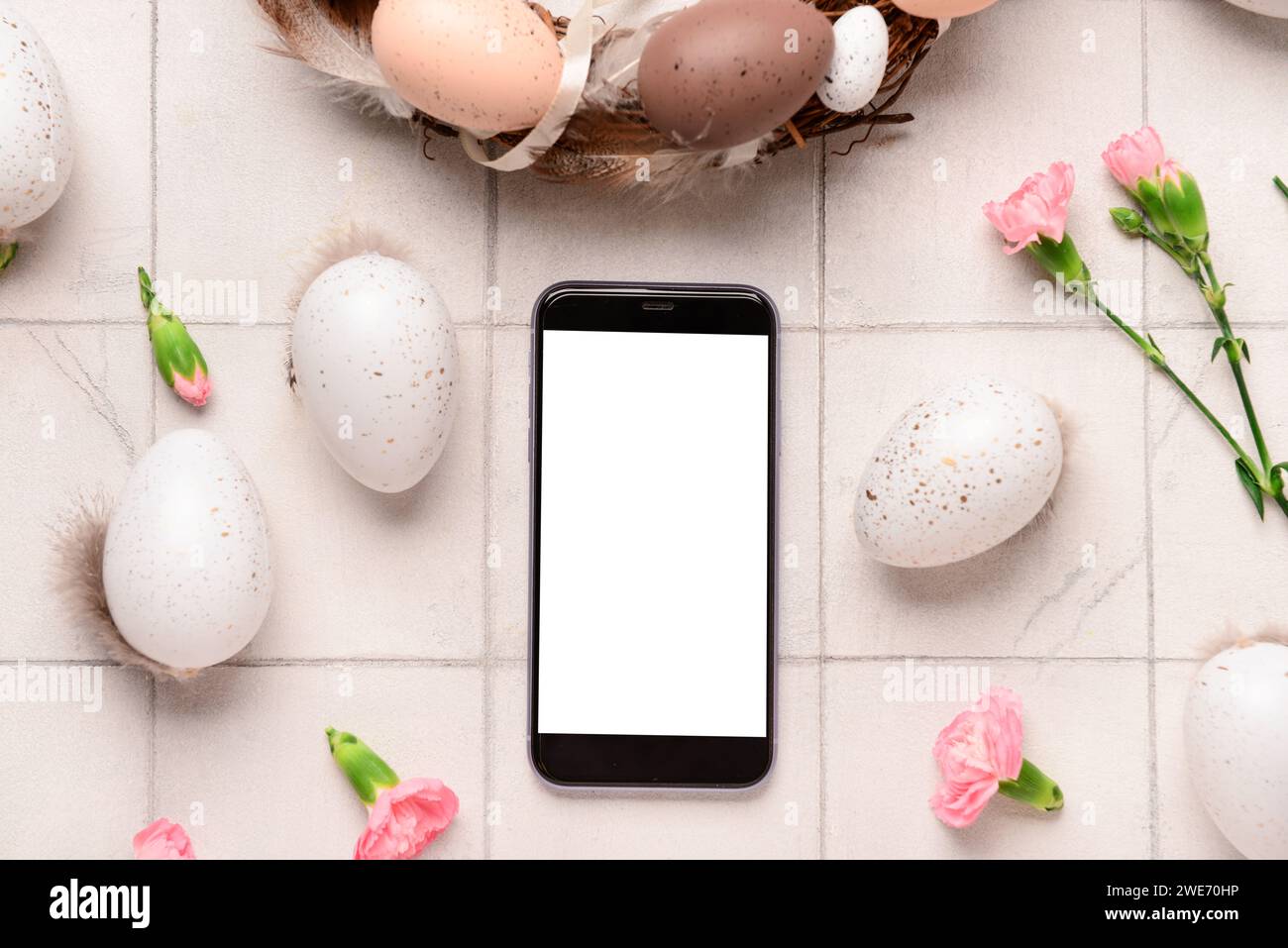 Composition with modern mobile phone, Easter eggs and flowers on light ...
