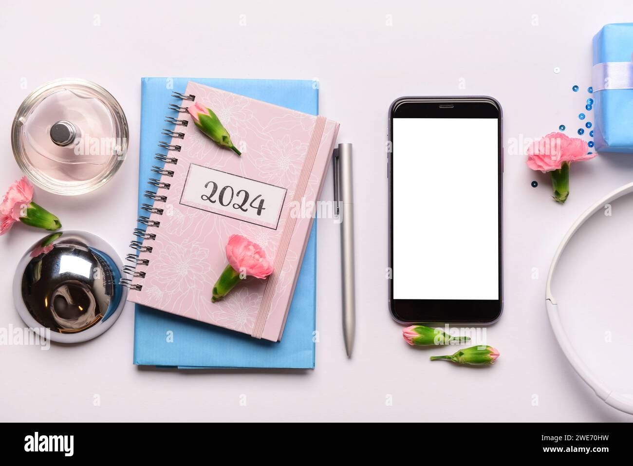 Composition with modern mobile phone, notebooks, perfume and flowers on ...