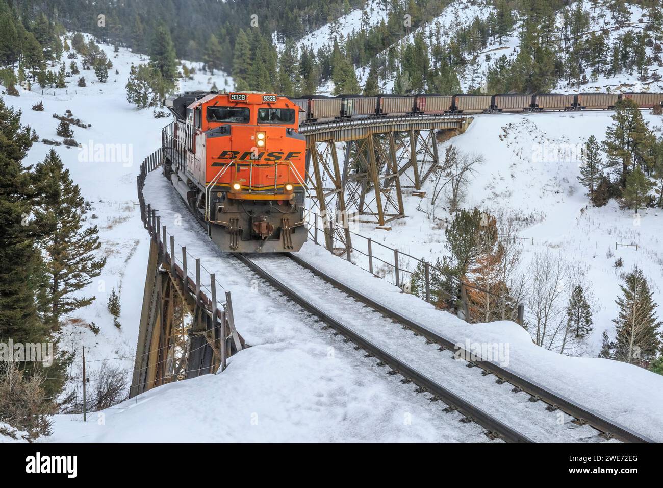 train hauling coal cars toward mullan pass over a trestle in winter ...