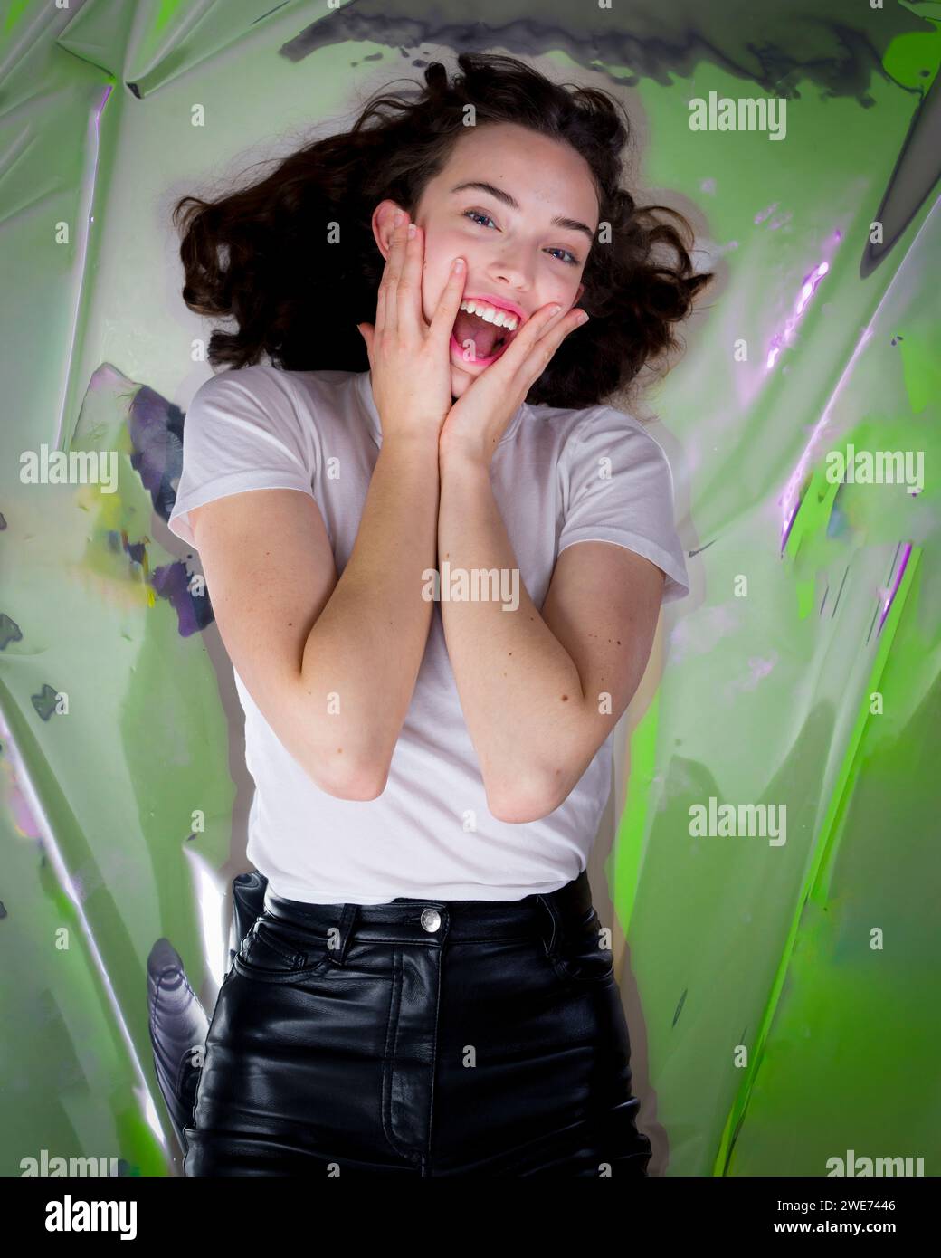 Teenage Girl Hands on Cheeks Laying on Back Looking at Camera Open ...