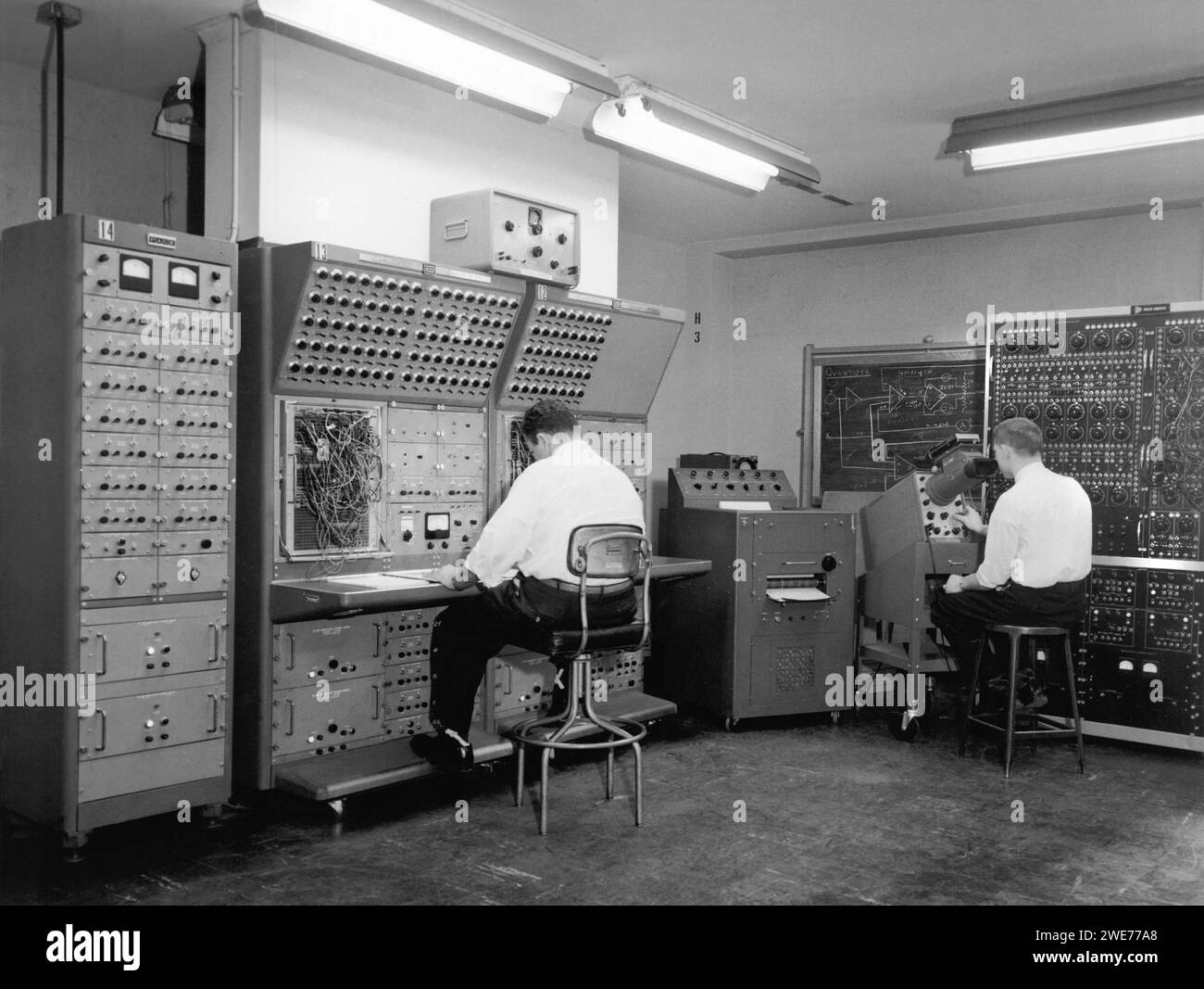 Men working on analogue computer Stock Photo - Alamy