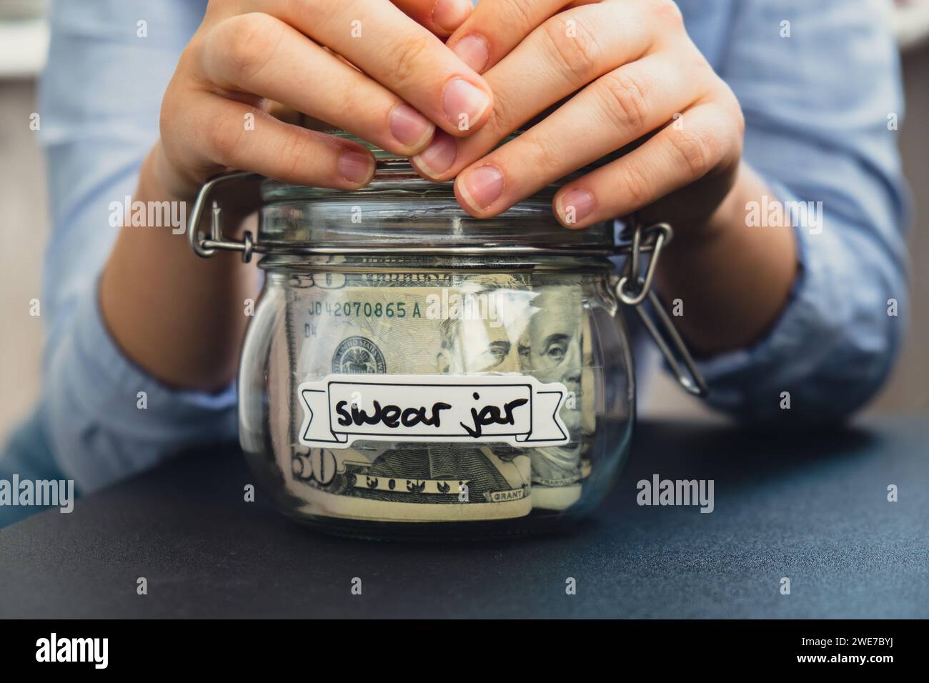 Female hands holding Glass jar full of American currency dollars cash ...