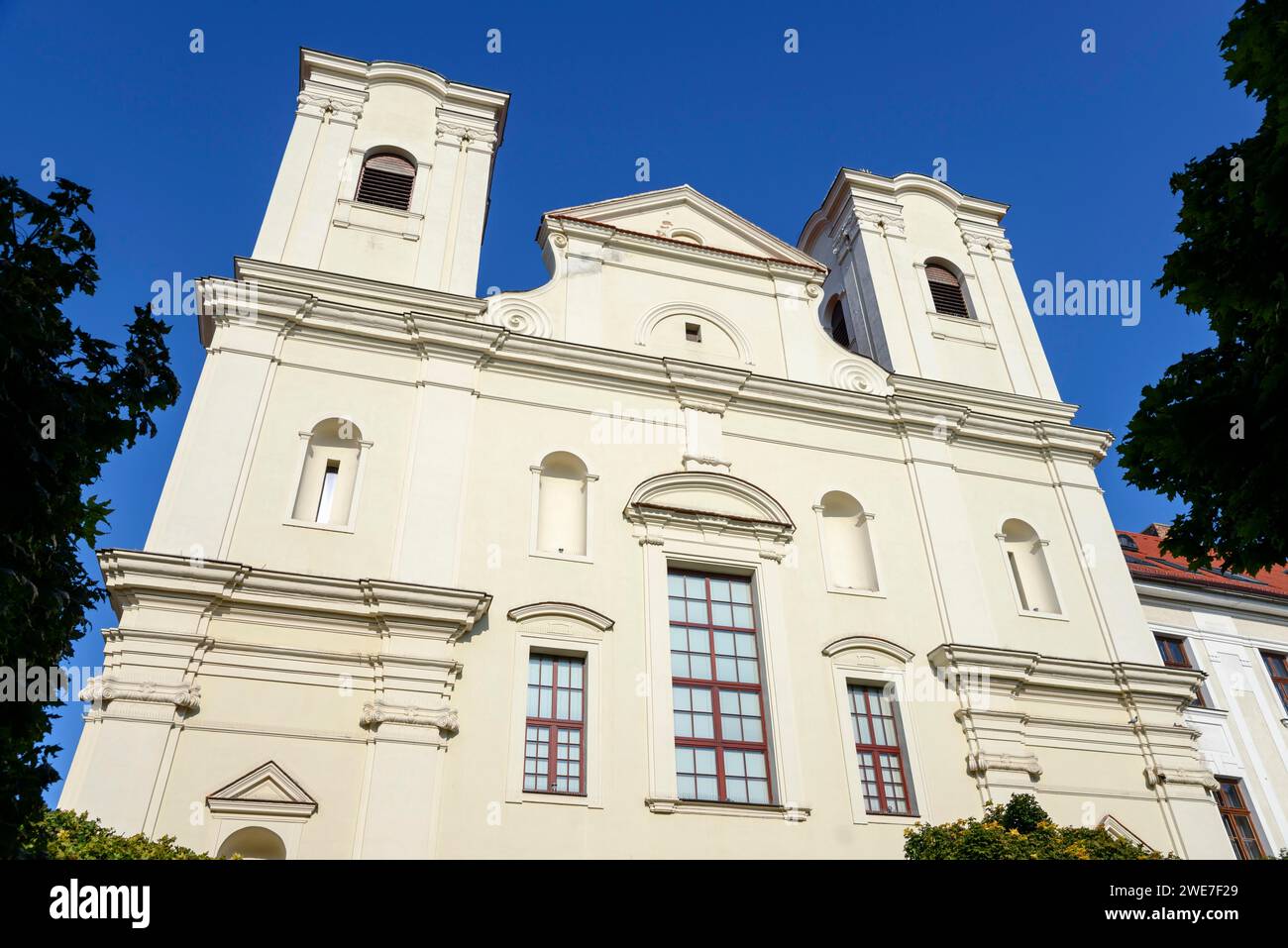 Baroque church facade with dominant towers under an intensely blue sky ...