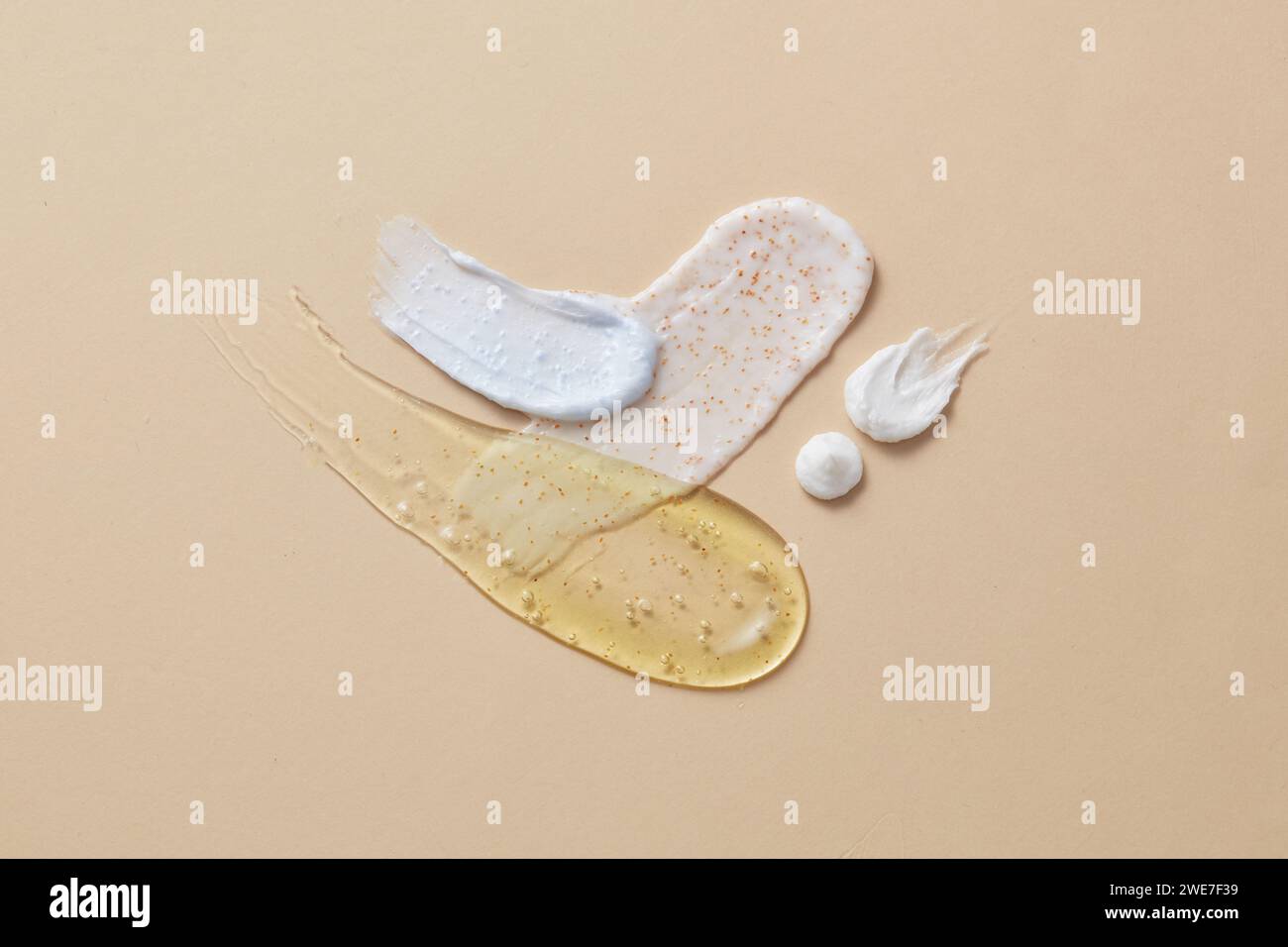 Different cosmetic textures of face cream, serum and lotion on beige ...