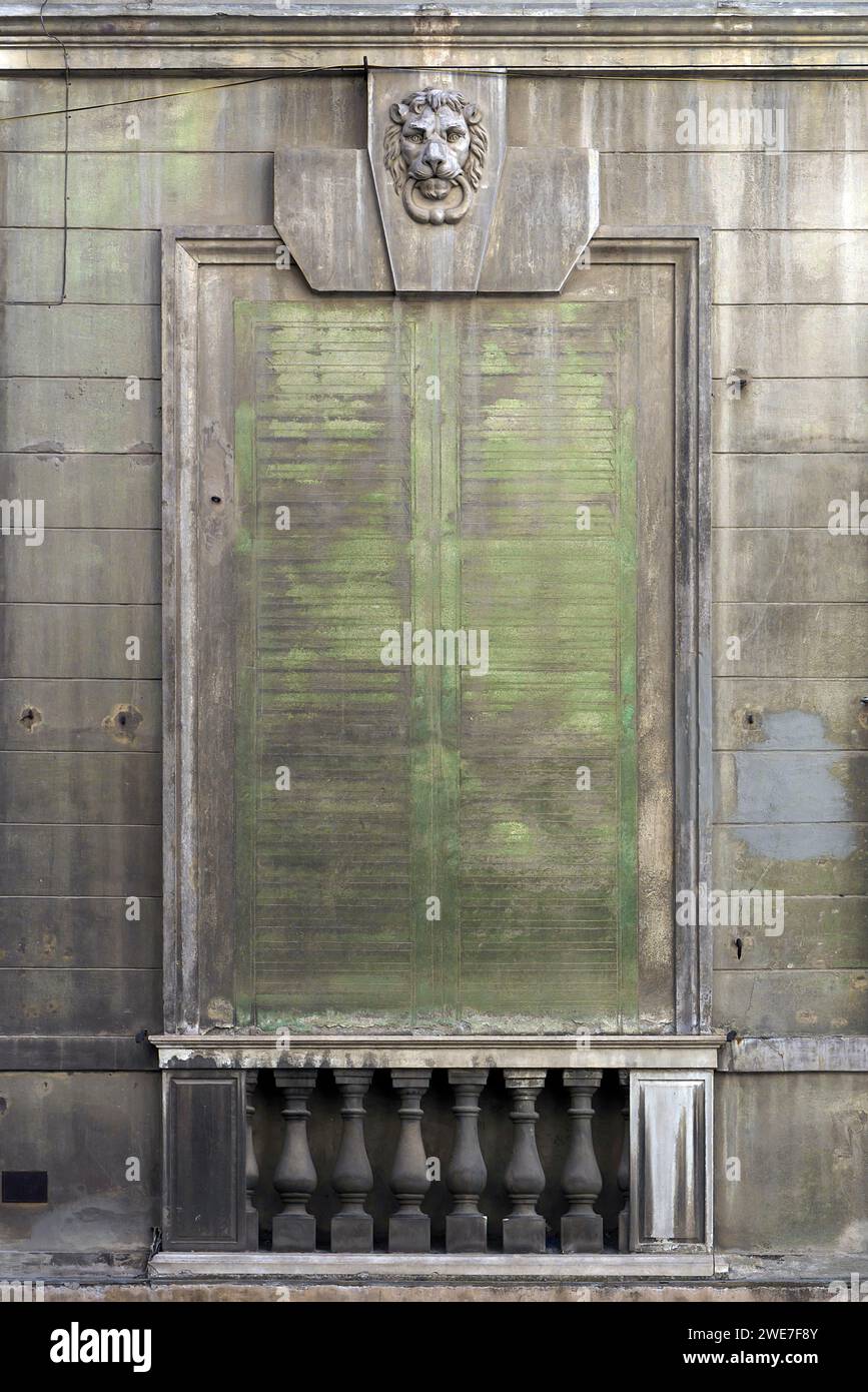 Lion's head above an emission-soiled window of an abandoned palazzo ...