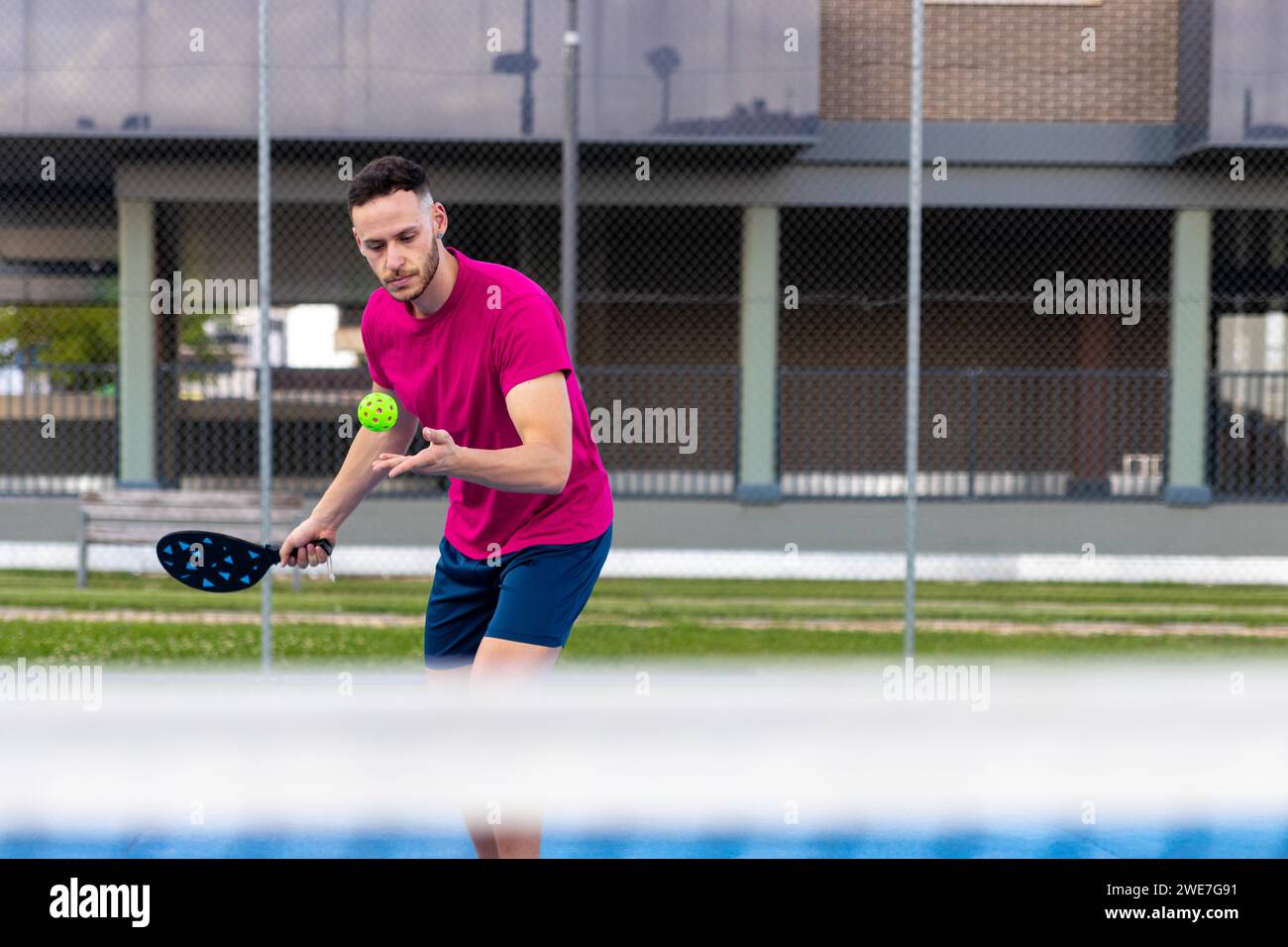 Portrait of a man performing a serve in pickleball. Sporty man ...