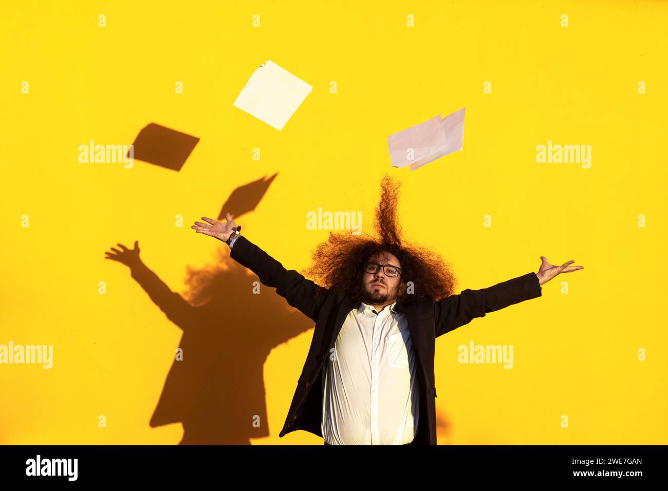 Portrait of long-haired businessman throwing papers and documents in ...