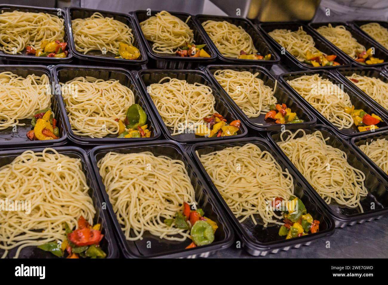 Several plastic serving containers filled with cooked spaghetti noodles ...
