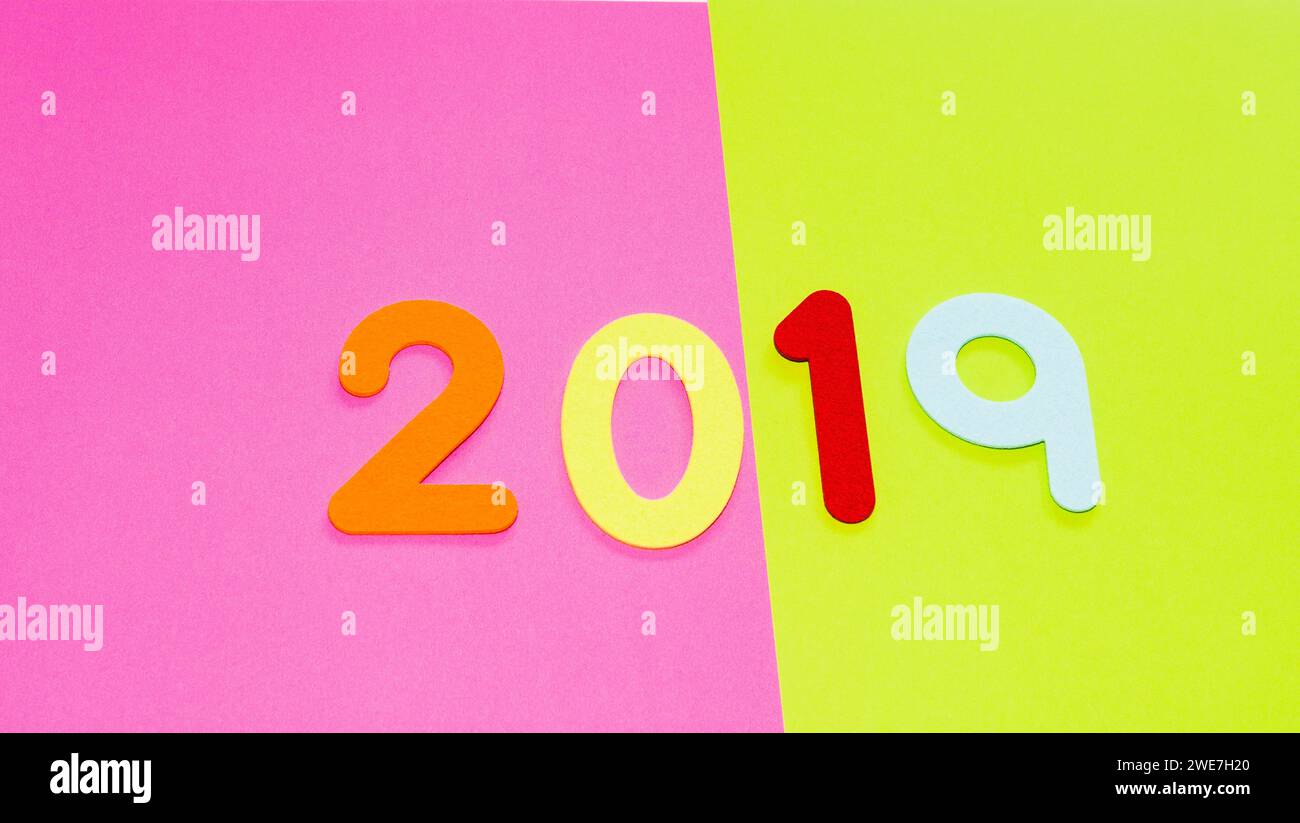 The numbers 2019 made of felt of different colors photographed on pink ...