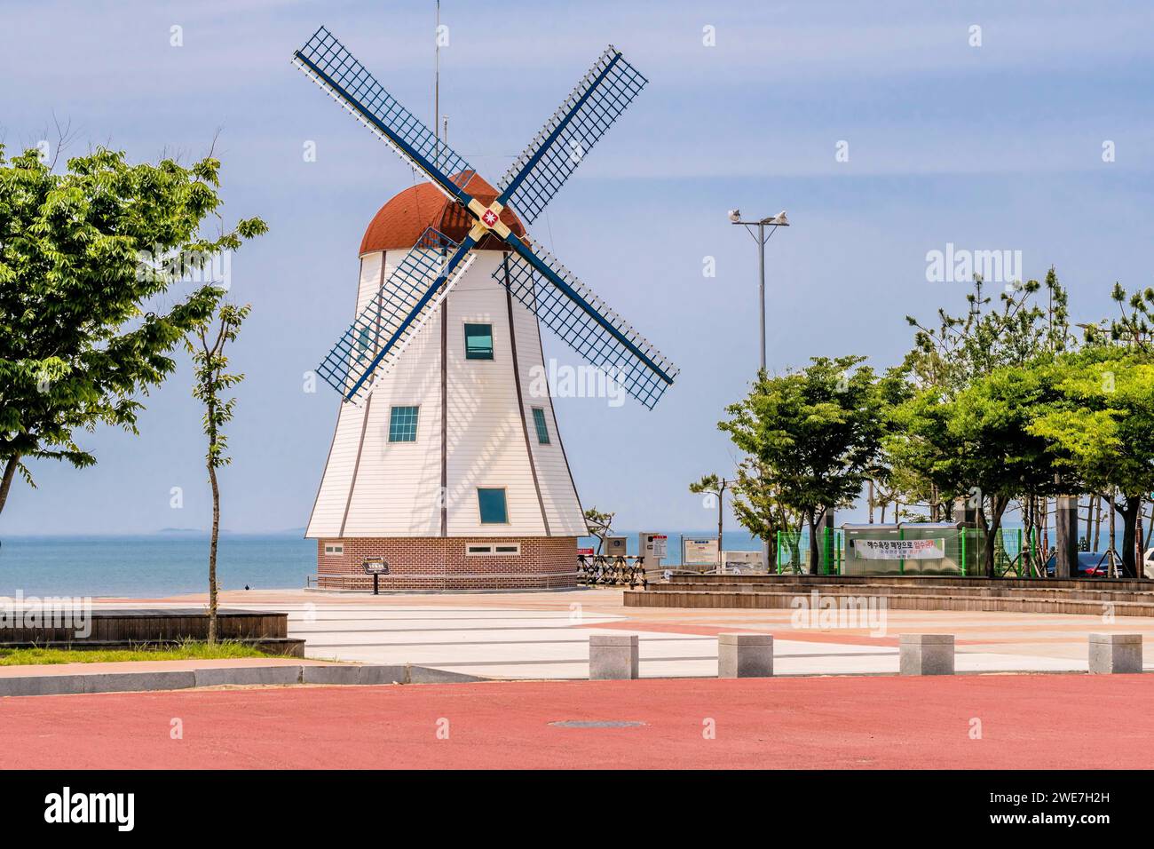 Windmill at seaside park with cloud streaked blue sky in background in ...