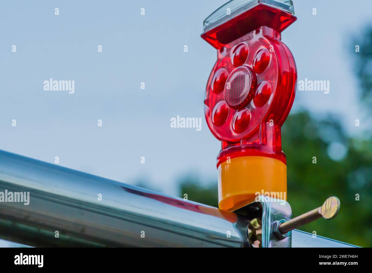 Closeup of red warning reflector with yellow base attached to chrome ...
