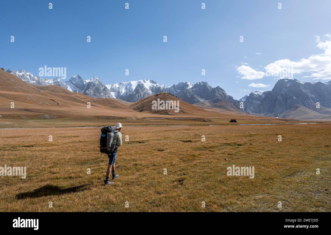 Mountaineer hiking to the mountain lake Kol Suu, mountain landscape ...