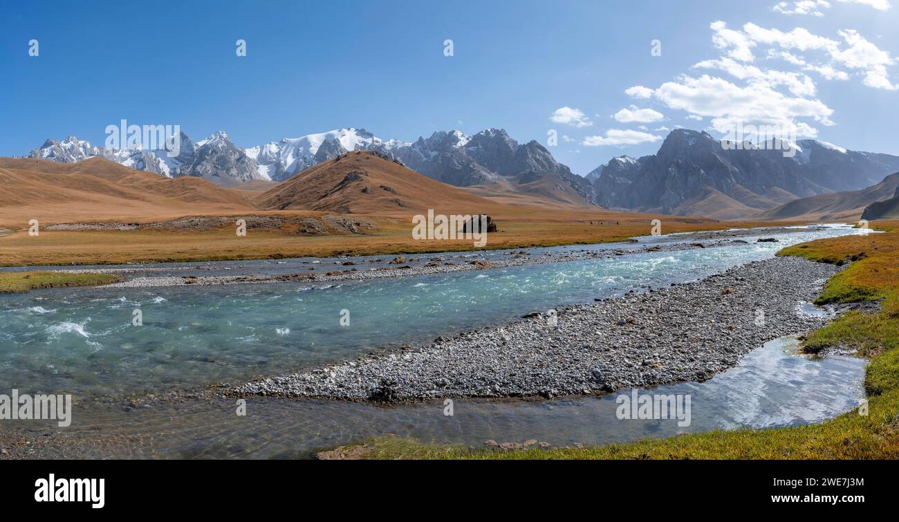 Mountain landscape with yellow meadows and river Kol Suu, mountain peak ...