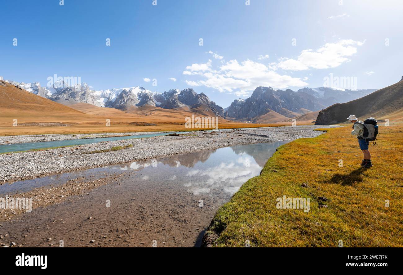 Mountaineer hiking to the mountain lake Kol Suu, mountain landscape ...