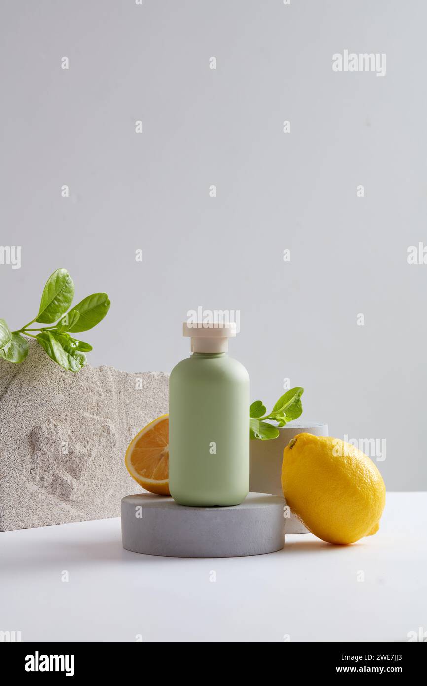 Pastel cosmetic bottle without label standing on gray podium with a ...