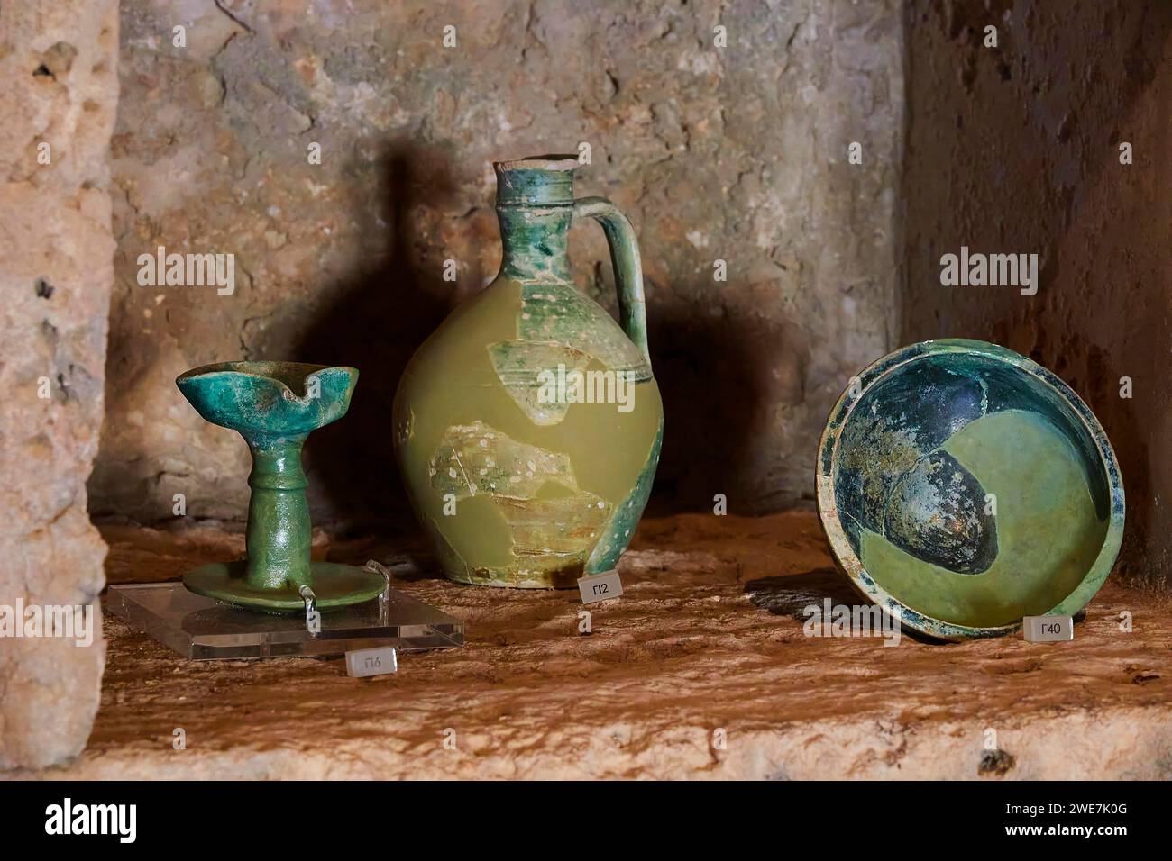 Ancient artefacts, including a vase and a bowl, displayed on a stone ...