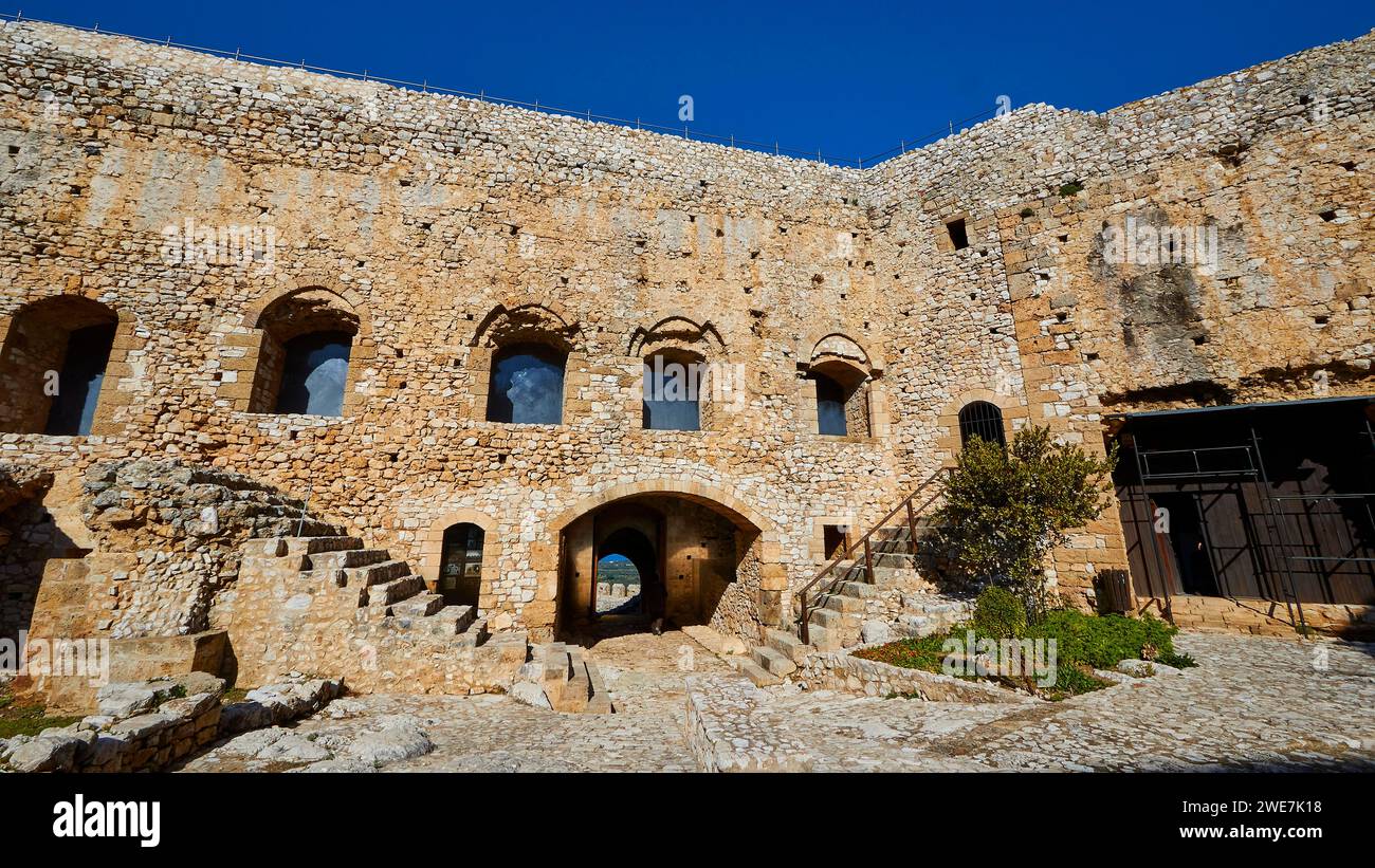 Inner courtyard of an old fortress with stone walls and arched windows ...