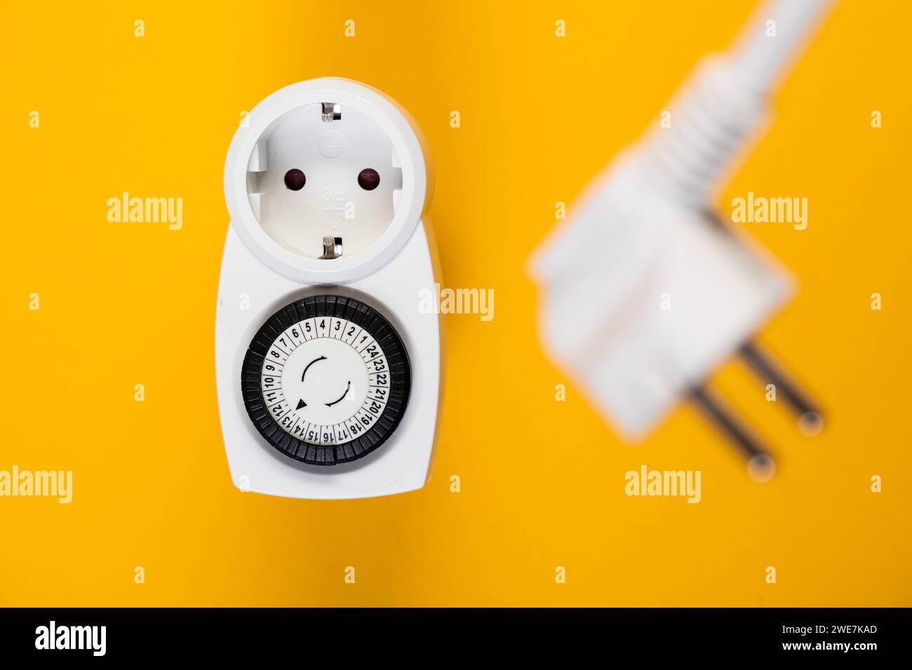 Timer with plug against a single-colour background Stock Photo - Alamy