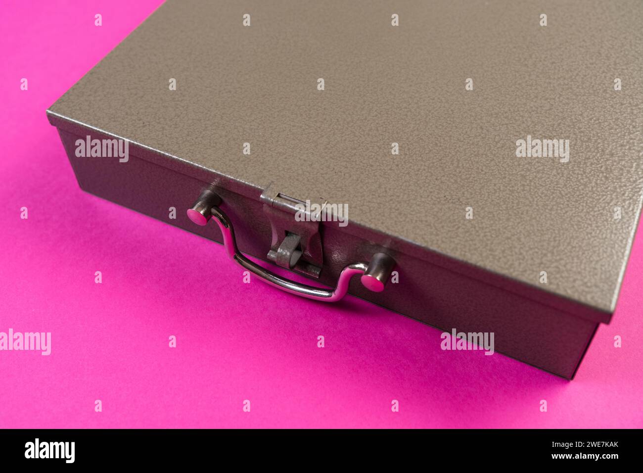 Cash box of a bank safe deposit box in front of a monochrome pink ...