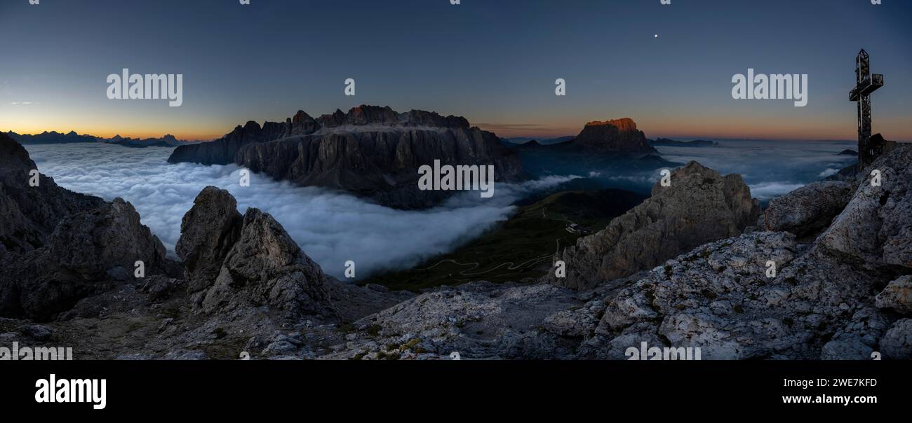 Summit cross of the large Cirrspitze with sunrise over a sea of fog and ...