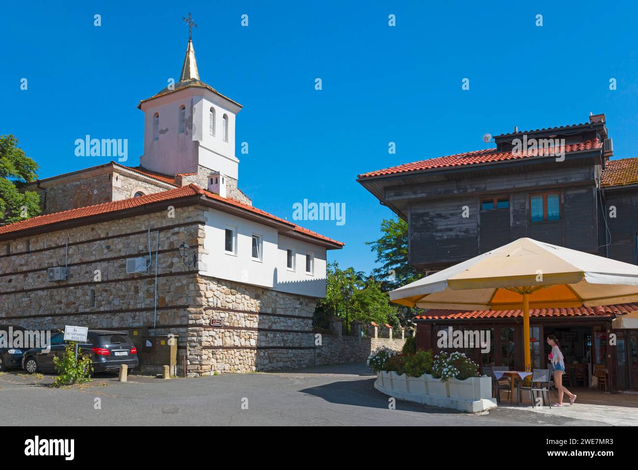 Historic church under clear blue sky next to urban buildings with ...