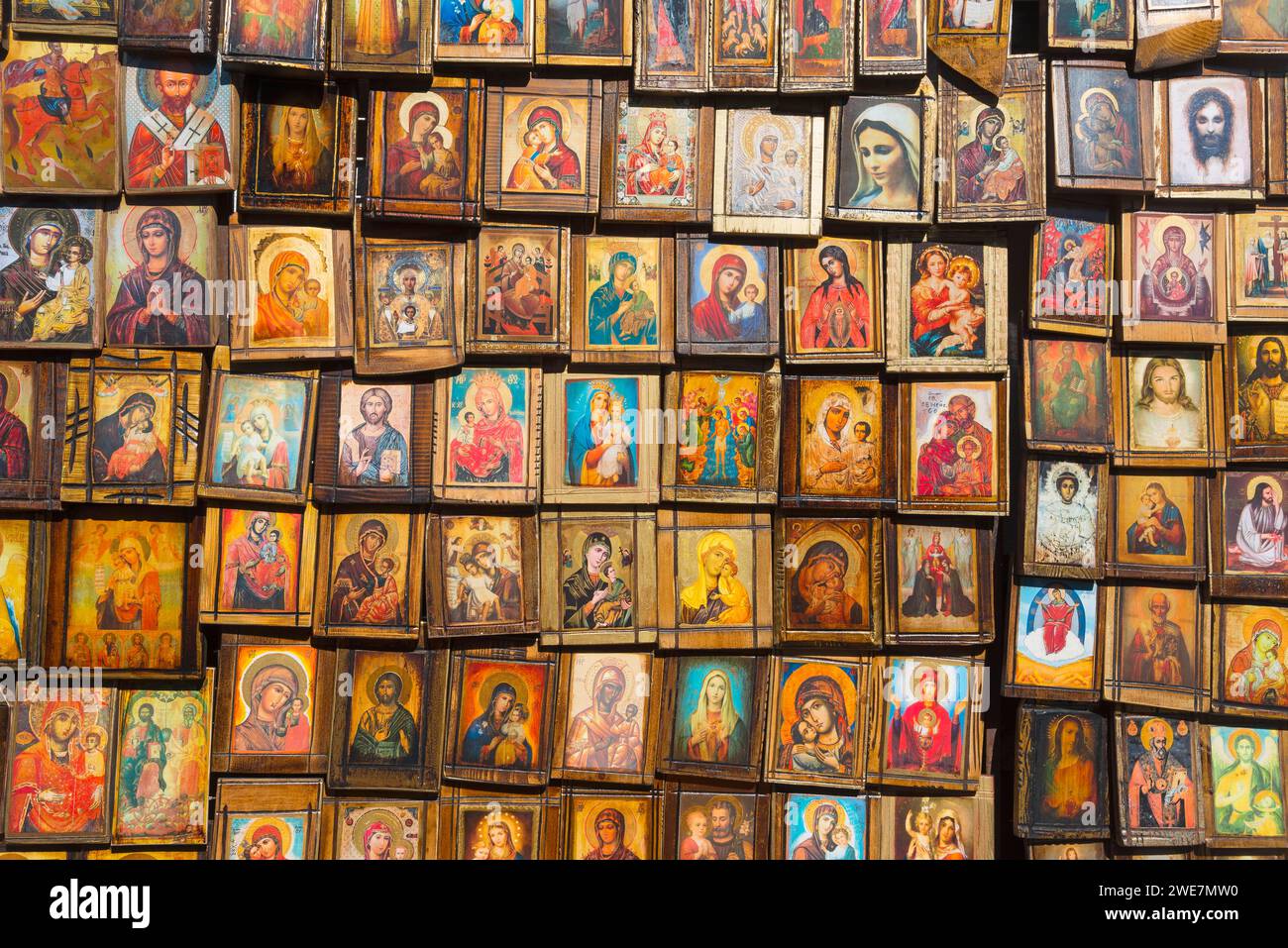 Wall full of colourful religious icons depicting various saints and ...