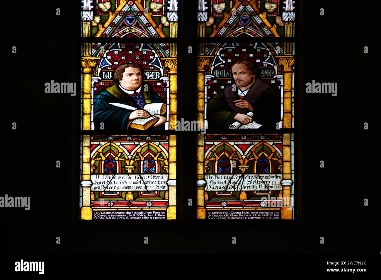 Colourful stained glass window with reformers Martin Luther with quill ...