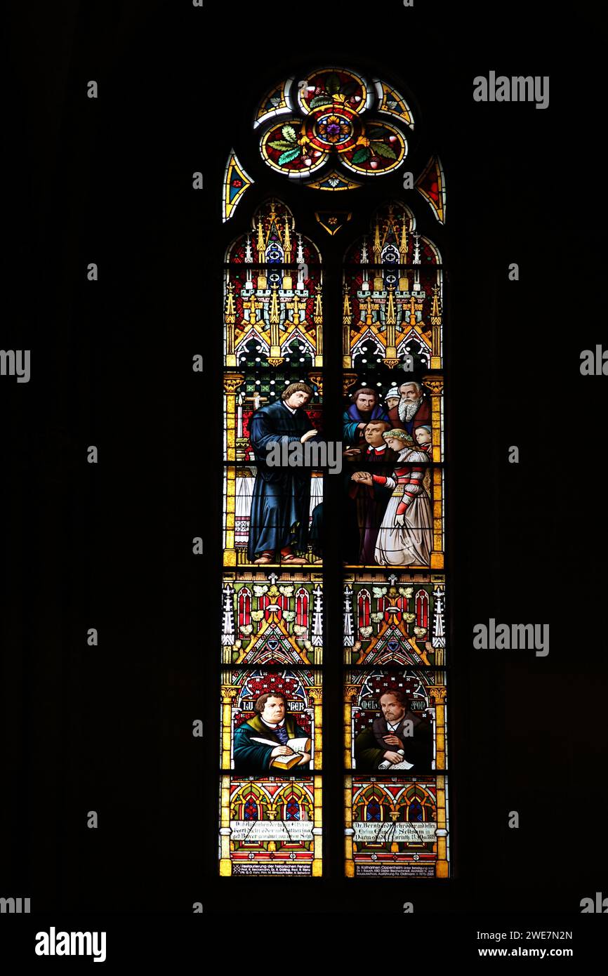 Colourful stained glass window with reformers Martin Luther with quill ...