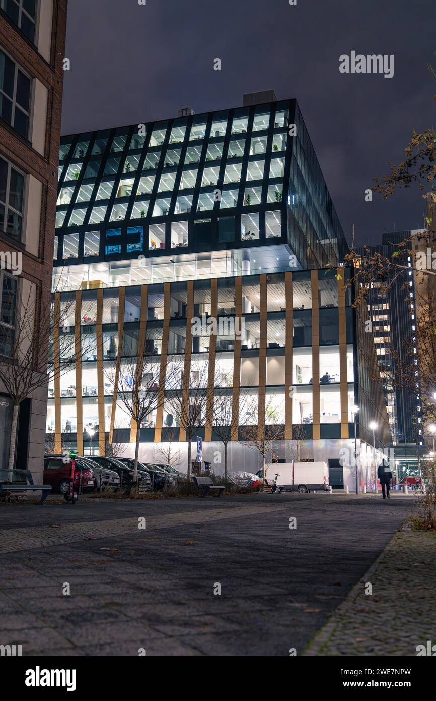 A modern office building at night with illuminated windows in an urban ...