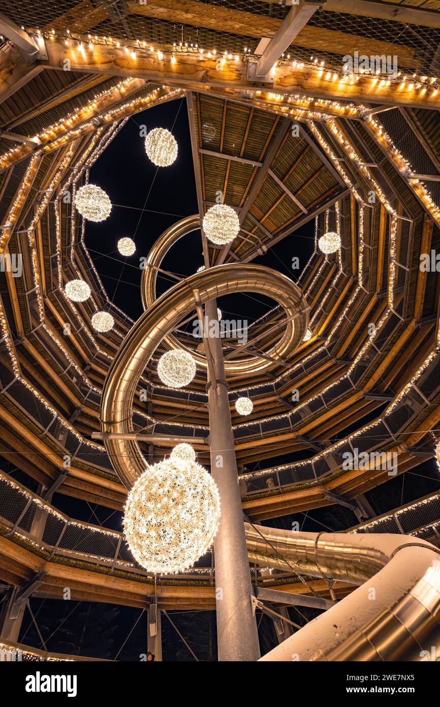 Spiral structure with fairy lights viewed from below, enchanting forest ...