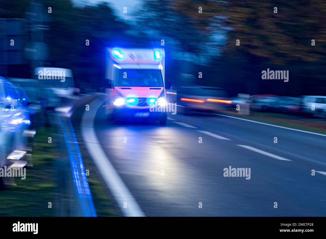 Emergency doctor with blue lights on duty on a country road, ambulance, rescue service, German ...