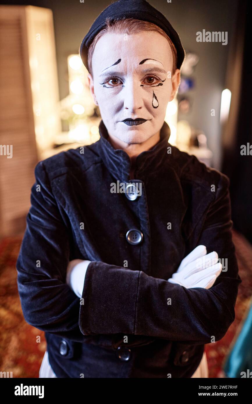 Vertical waist up portrait of female mime performer looking at camera ...