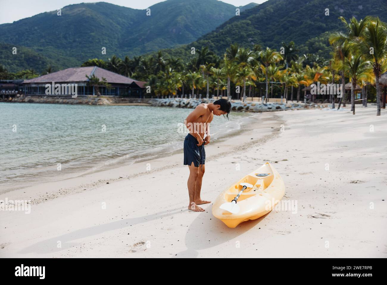 Happy Asian Man Paddling Kayak on Tropical Beach Stock Photo - Alamy