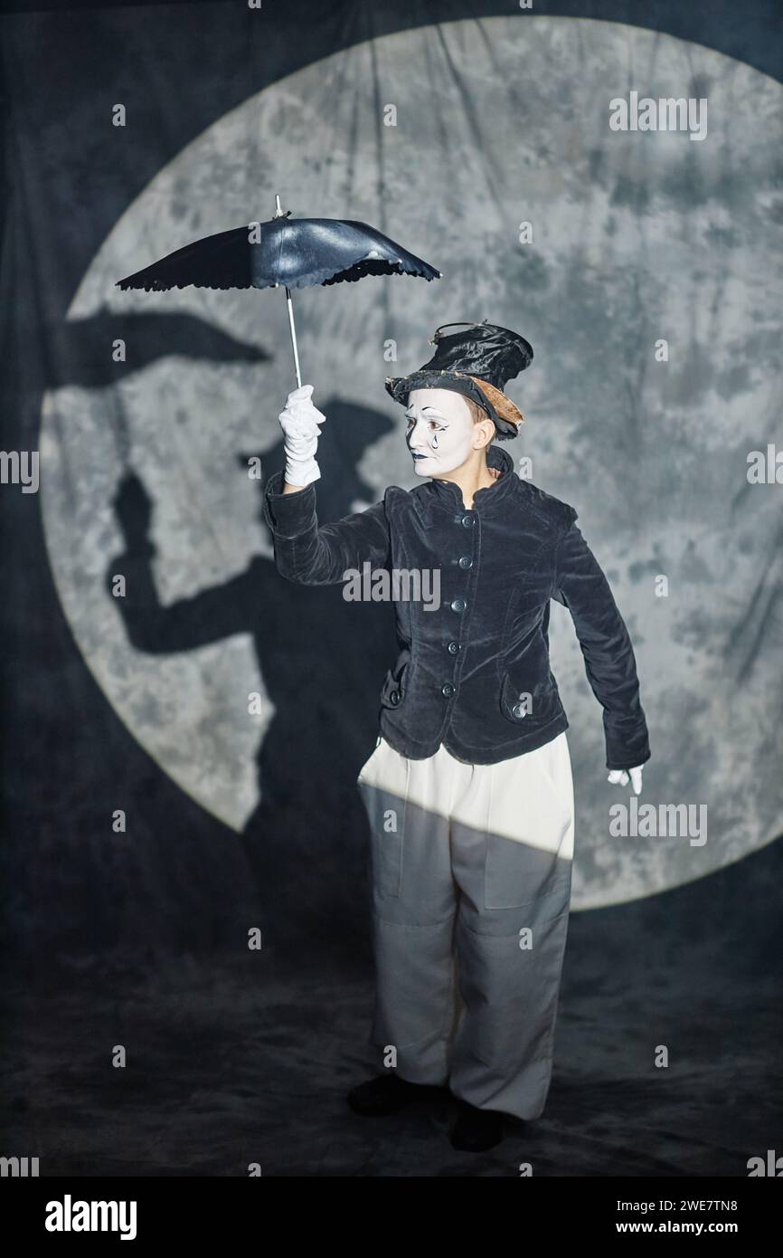 Vertical full length portrait of classic mime performer acting on stage ...