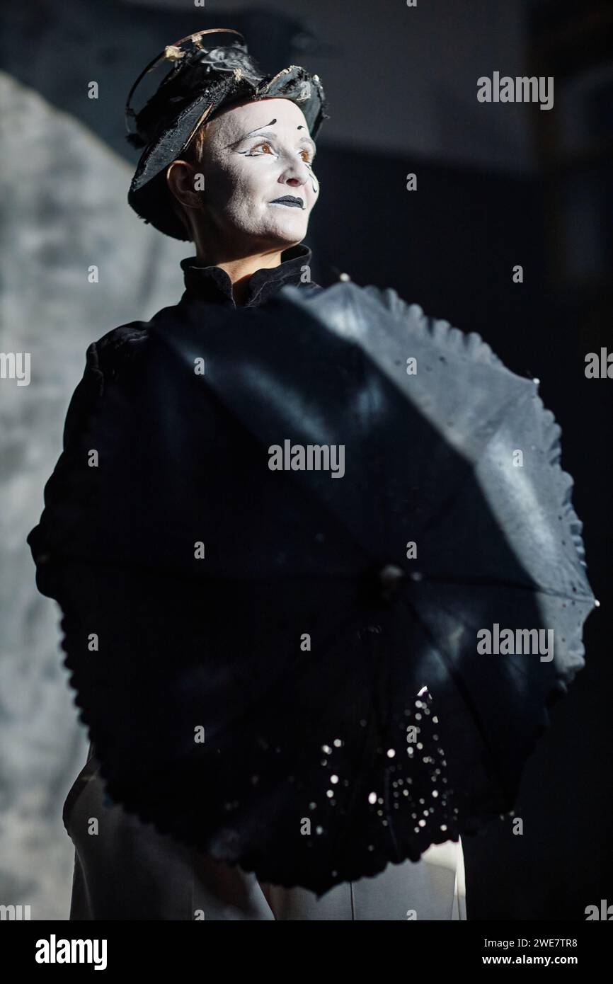 Dramatic low angle portrait of female mime performer acting on stage in ...
